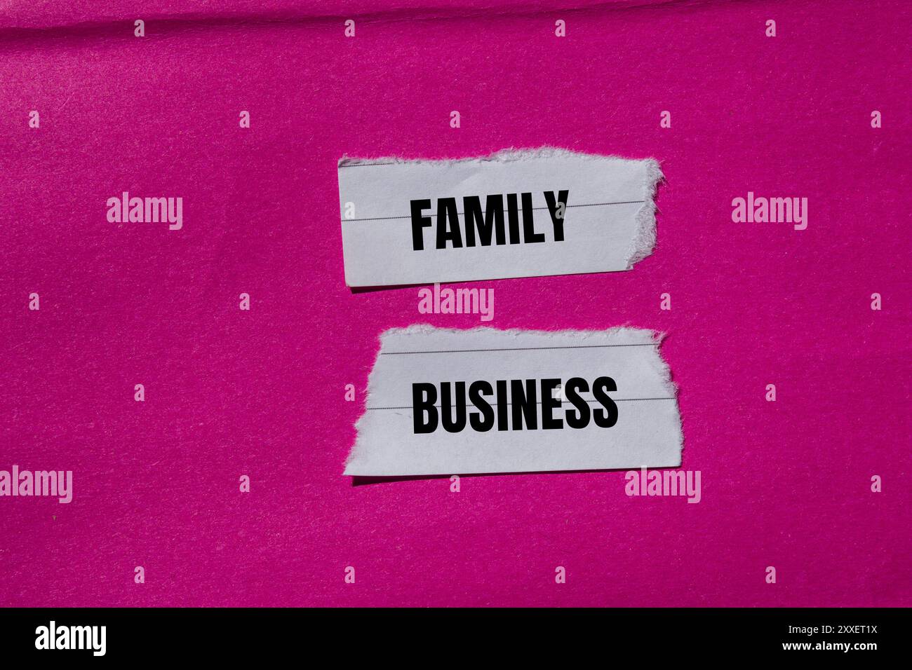 Family business message written on ripped torn paper pieces with pink ...