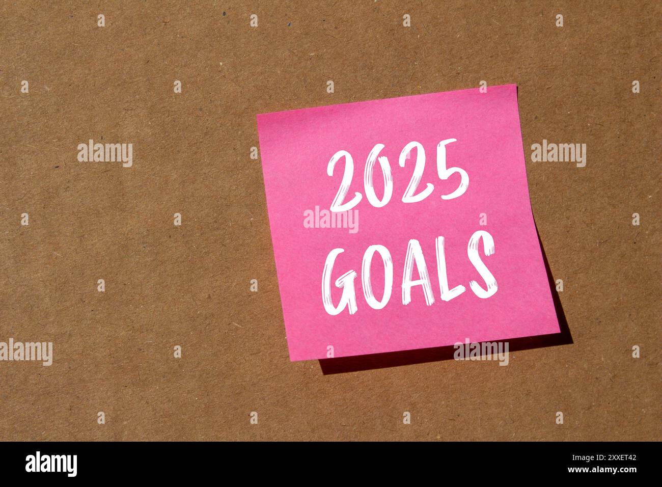2025 goals message written on pink paper with cardboard background ...