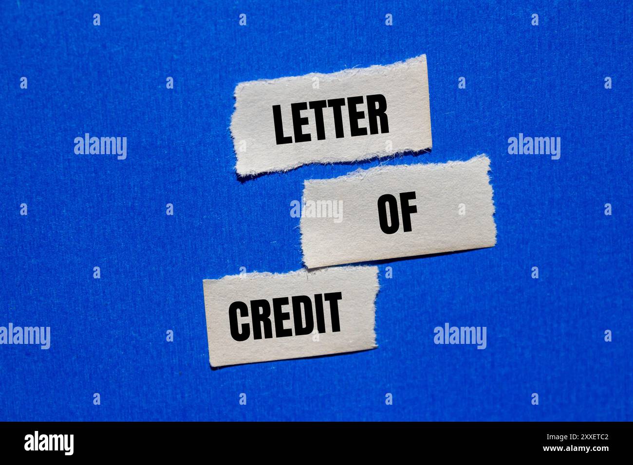 Letter of credit message written on ripped torn paper peices with blue ...