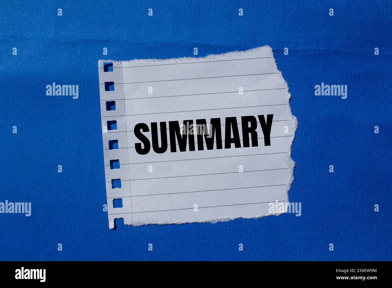 Summary message written on ripped torn paper piece with blue background ...