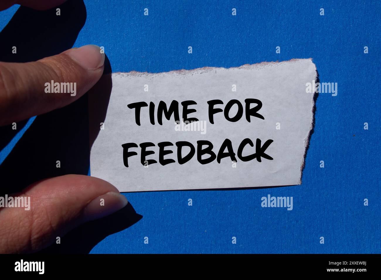 Time for feedback message written on ripped torn paper with blue ...
