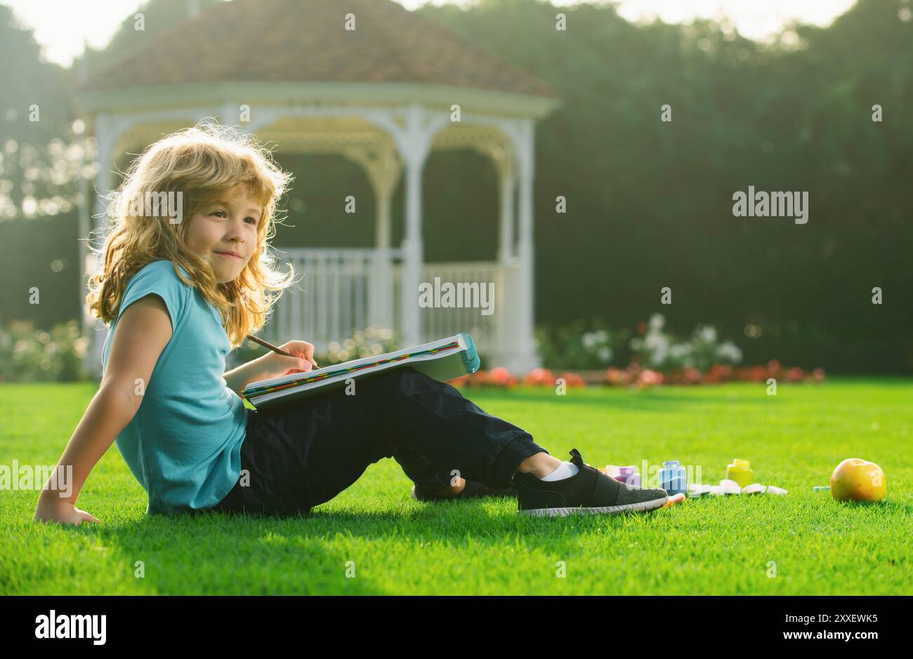 Kid draws in park having fun on nature background. Children creative ...