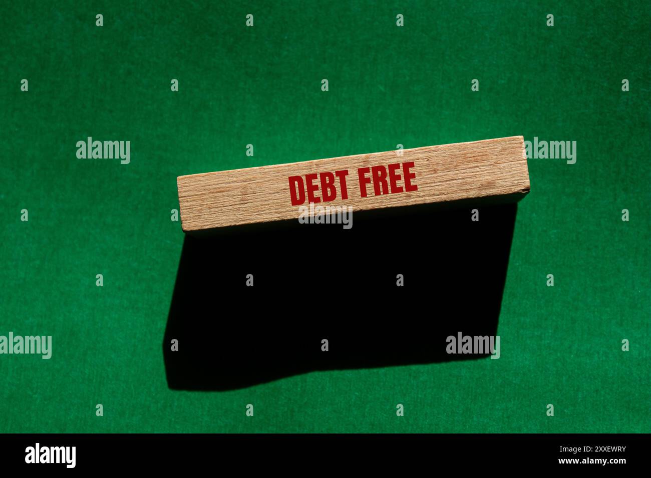Debt free message written on wooden block with green background ...