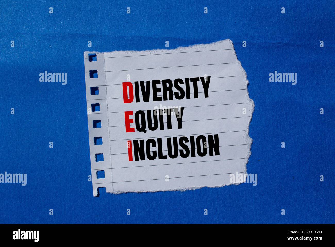 Diversity equity and inclusion message written on ripped torn paper piece with blue background ...