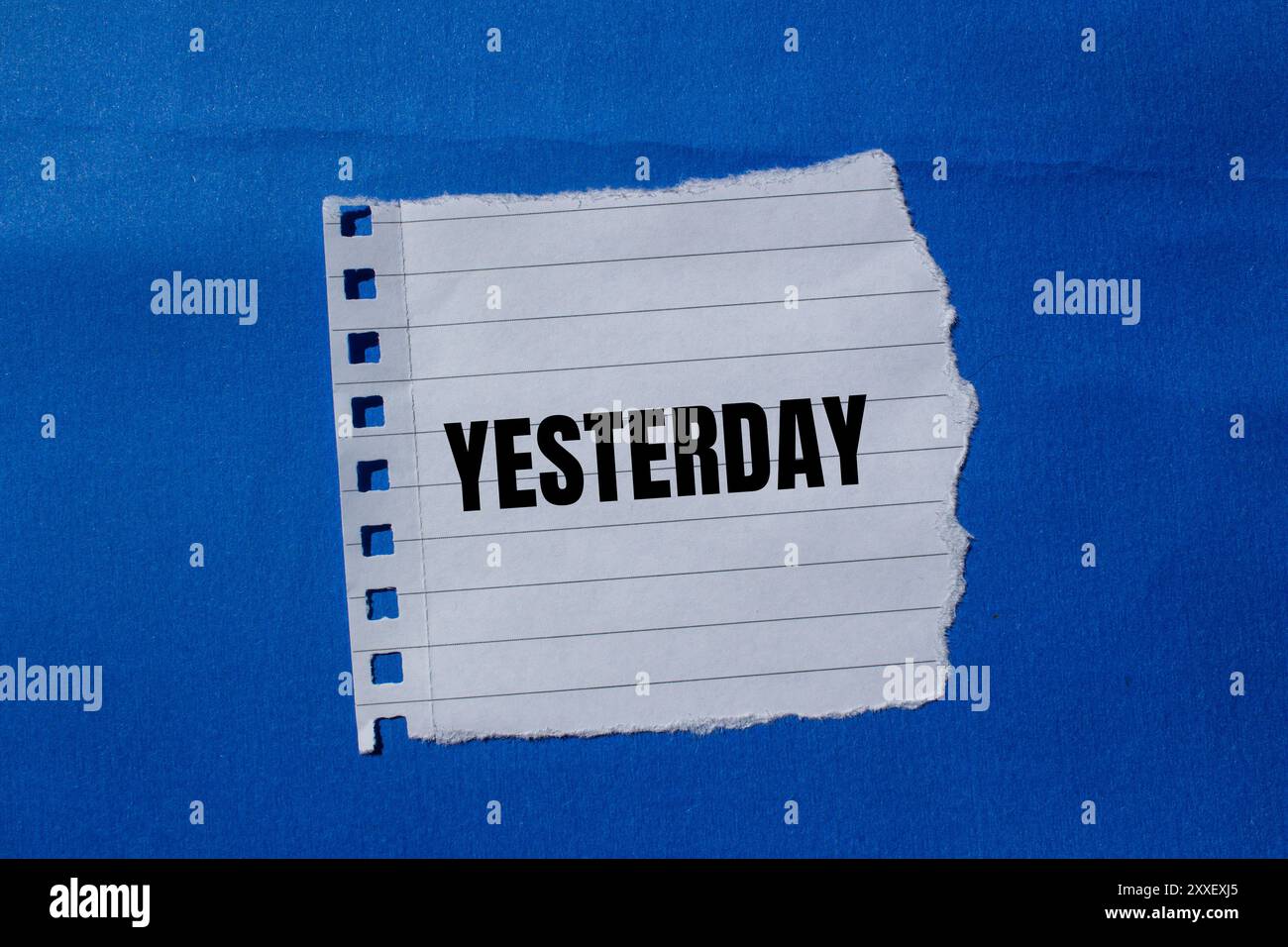 Yesterday message written on ripped torn paper piece with blue ...