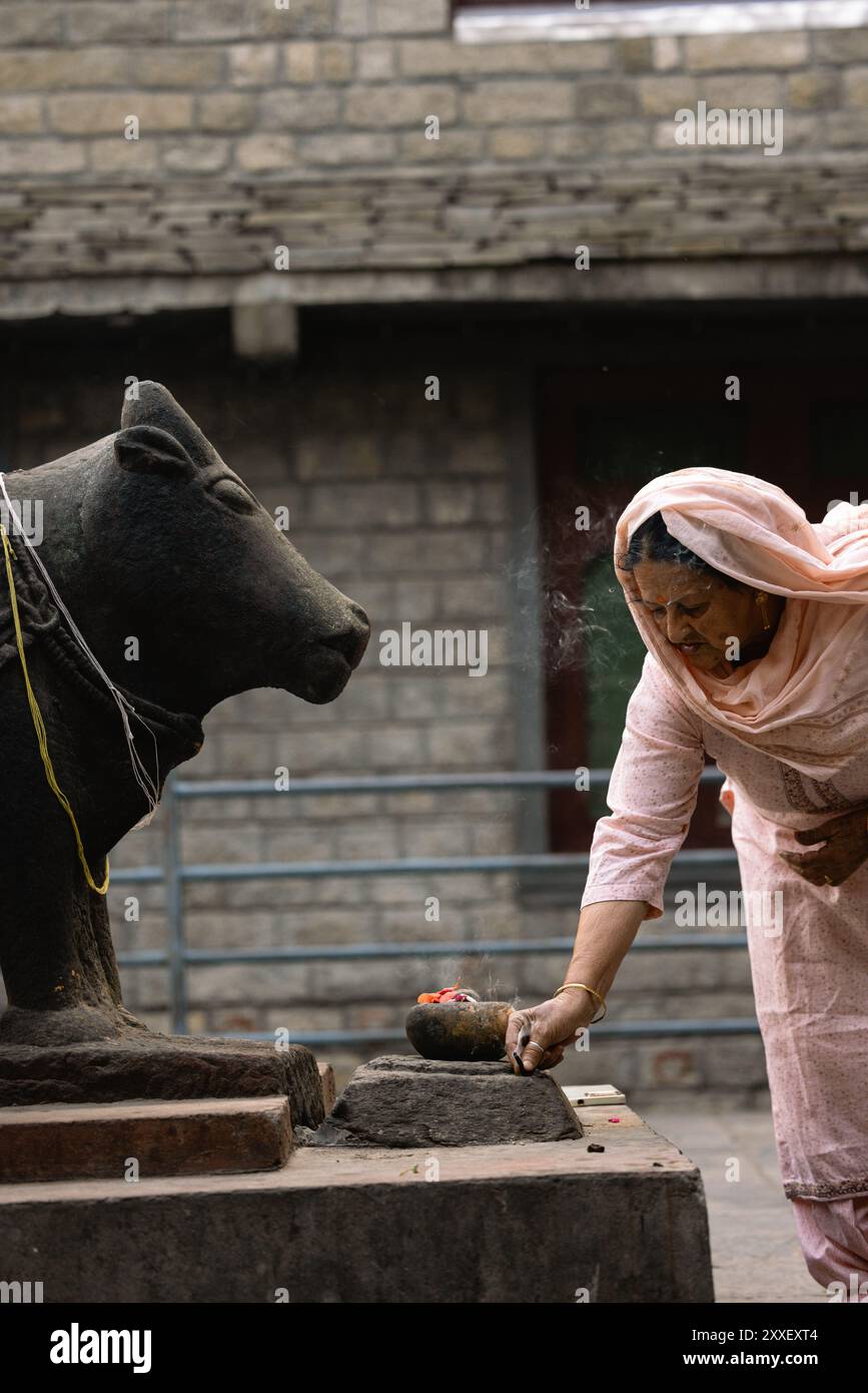 NAGGAR, INDIA - 21 JUNE 2024: A local resident offers offerings in the ...