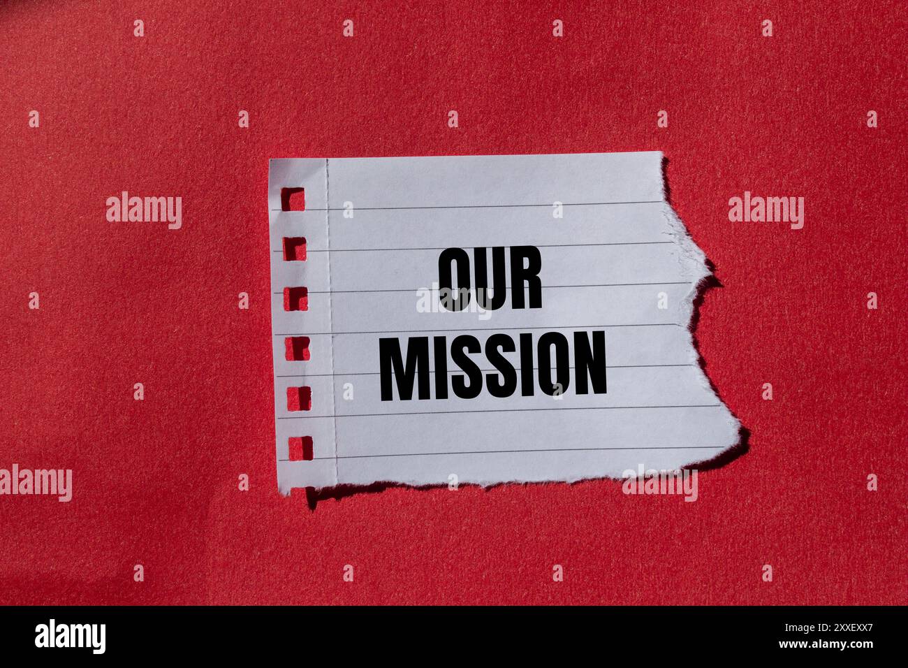 Our mission message written on ripped torn paper with red background. Conceptual our mission ...