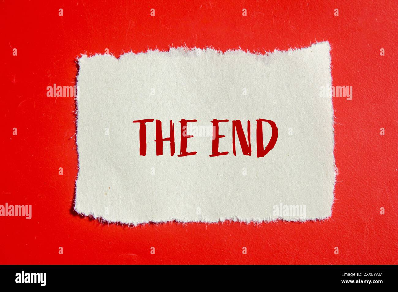 The end message written on ripped torn paper piece with red background ...