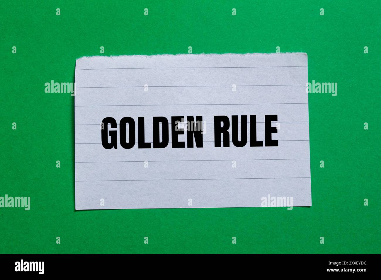 Golden rule message written on ripped torn paper piece with green ...