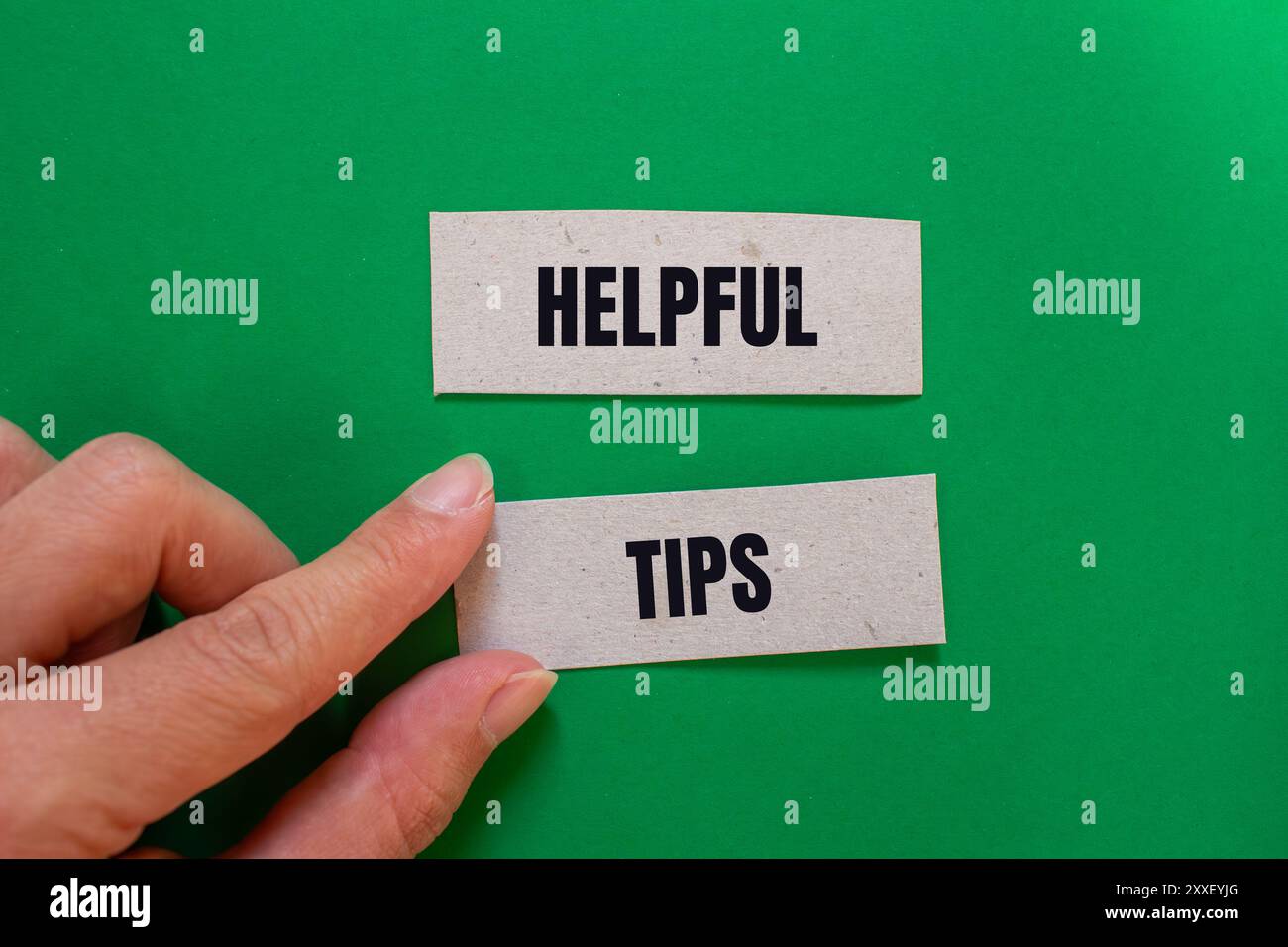 Helpful tips message written on paper pieces with green background ...