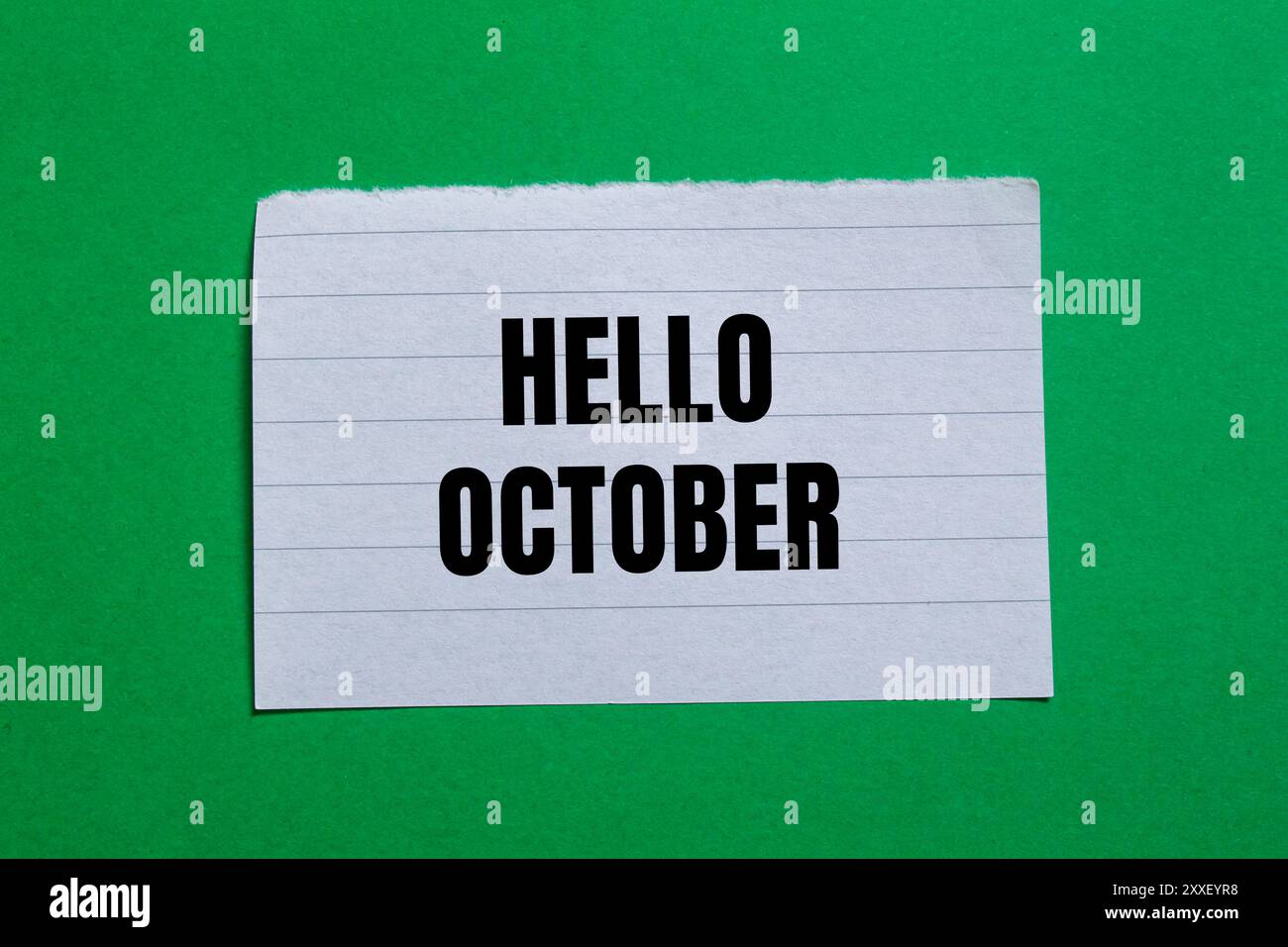 Hello october message written on ripped torn paper piece with green ...