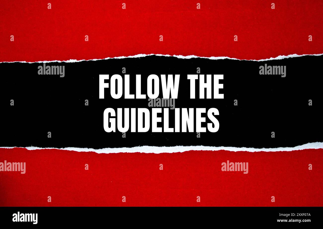 Follow the guidelines message written on ripped torn red paper with black background. Conceptual ...