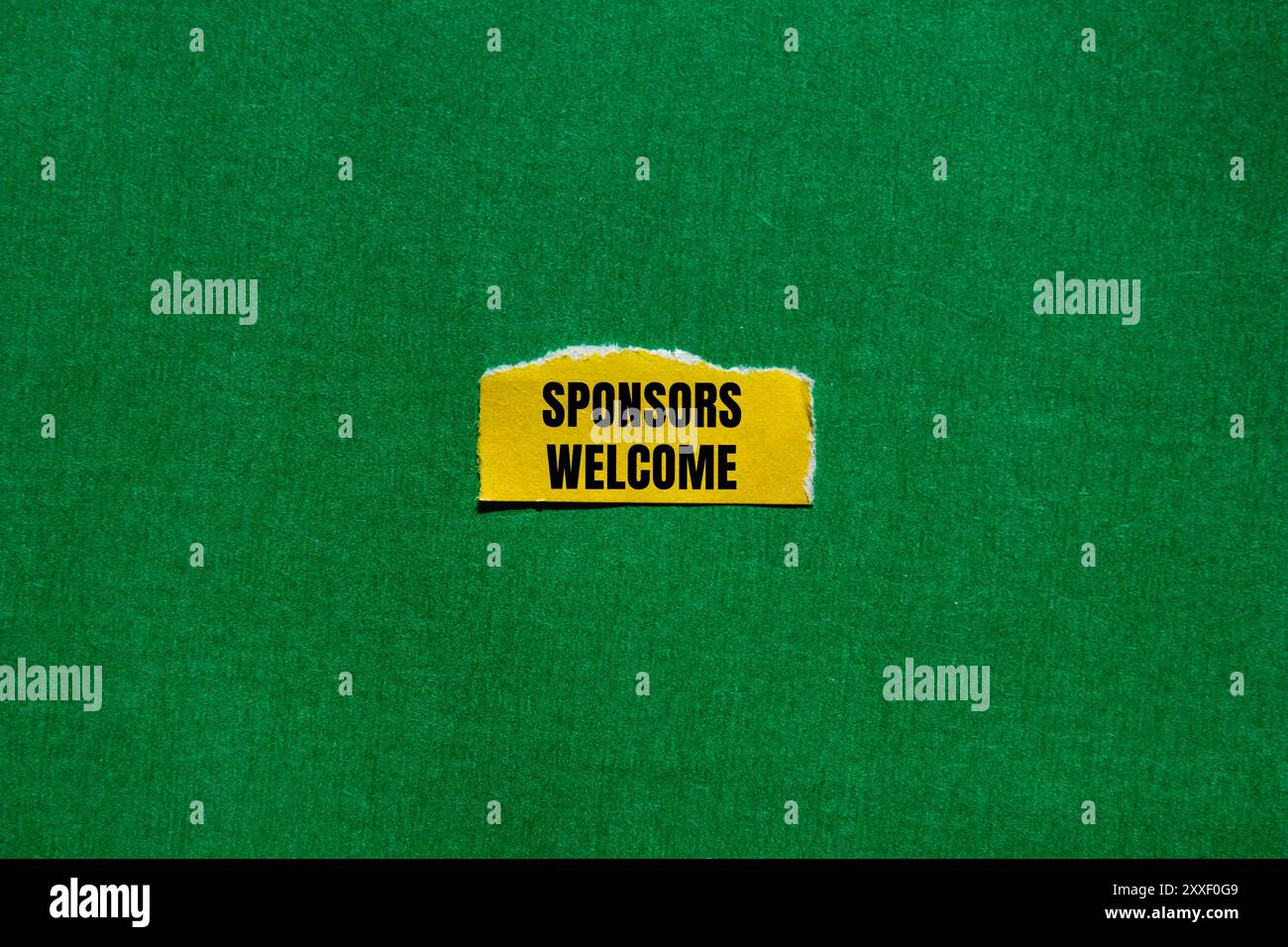 Sponsors welcome message written on ripped torn yellow paper piece with ...