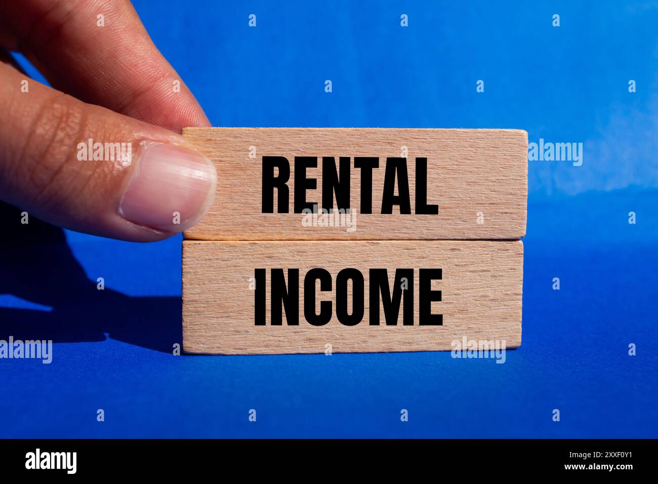 Rental income message written on wooden blocks with blue background ...