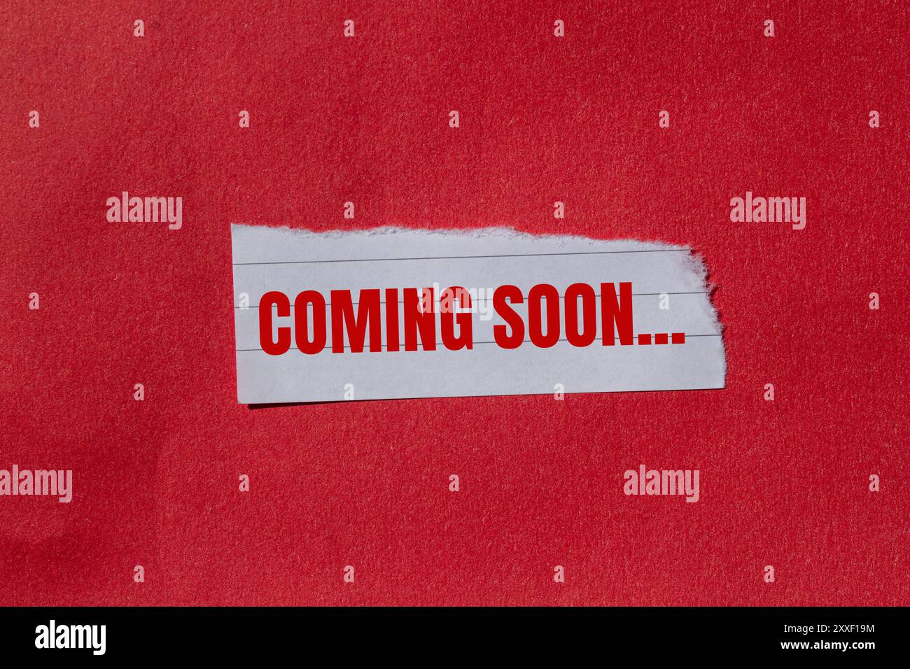 Coming soon message written on ripped torn paper piece with red ...