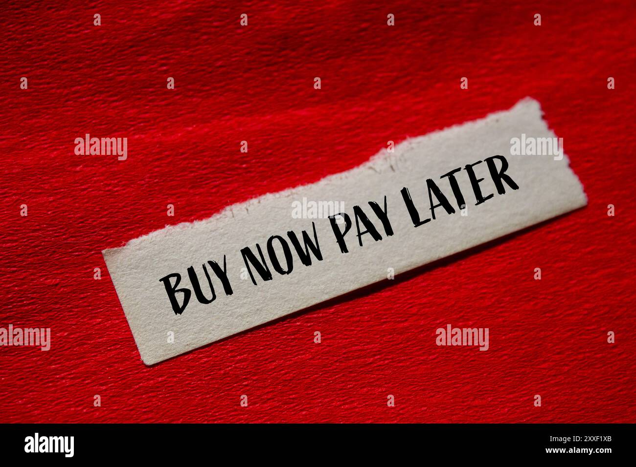 Buy now pay later message written on torn paper with red background ...