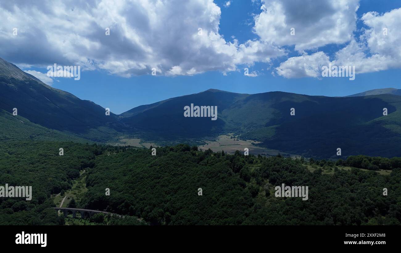 Vast green hills stretch across the countryside, kissed by fluffy ...