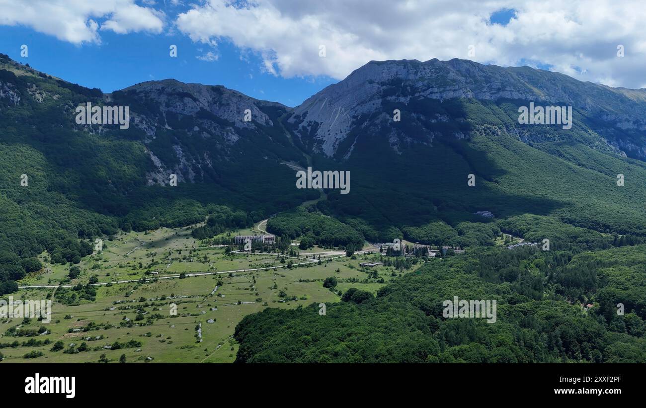 A breathtaking view showcases a lush green valley surrounded by ...