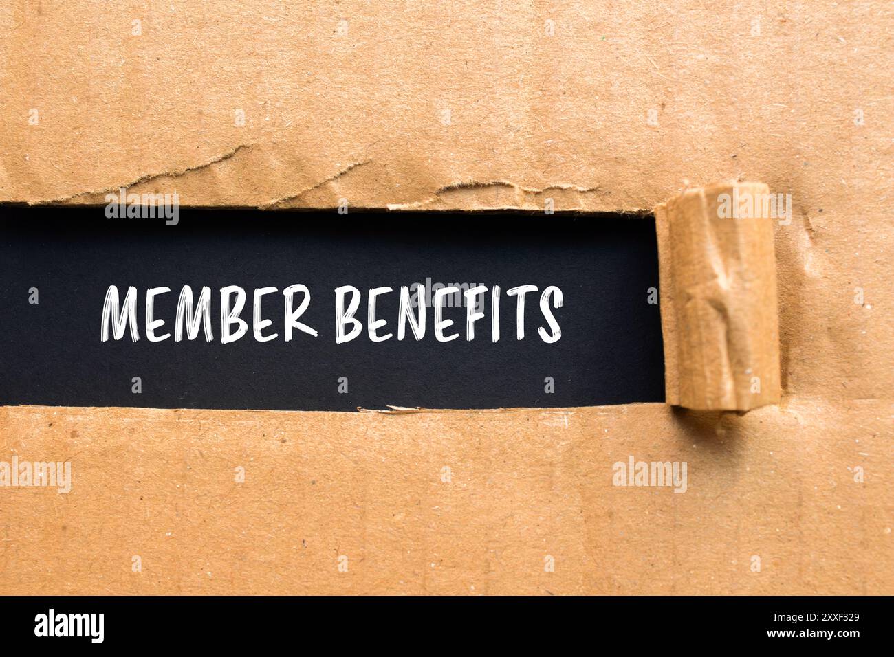 Member benefits message written on ripped torn cardboard paper with black background. Conceptual ...