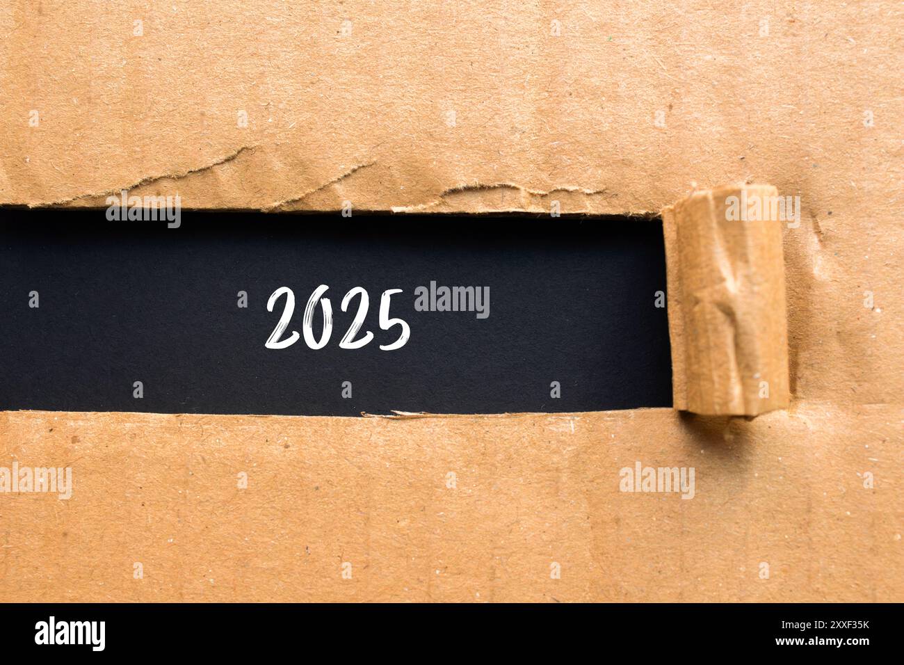 2025 message written on ripped torn cardboard paper with black background. Conceptual 2025 ...