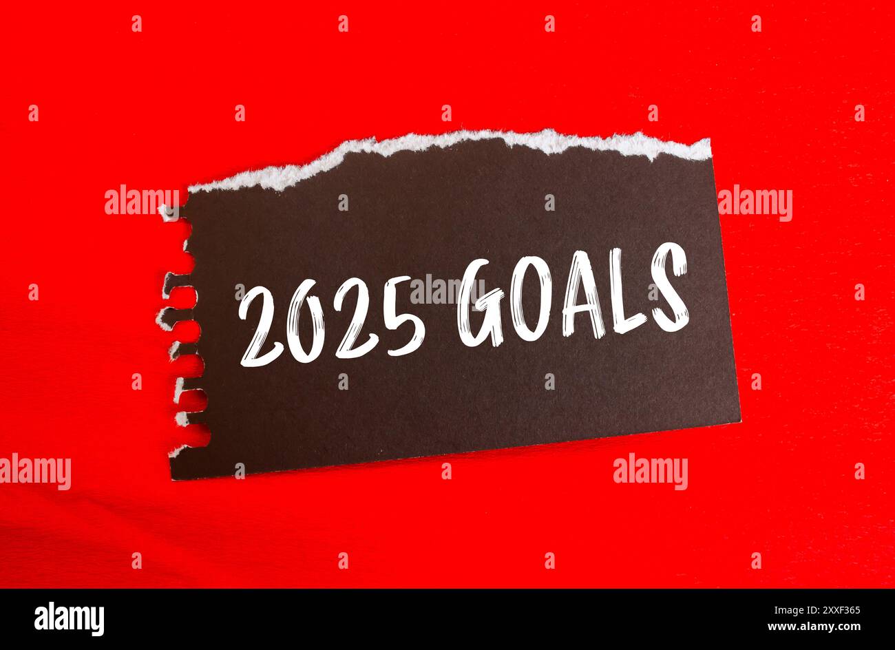 2025 goals message written on ripped torn black paper piece with red background. Conceptual 2025 ...