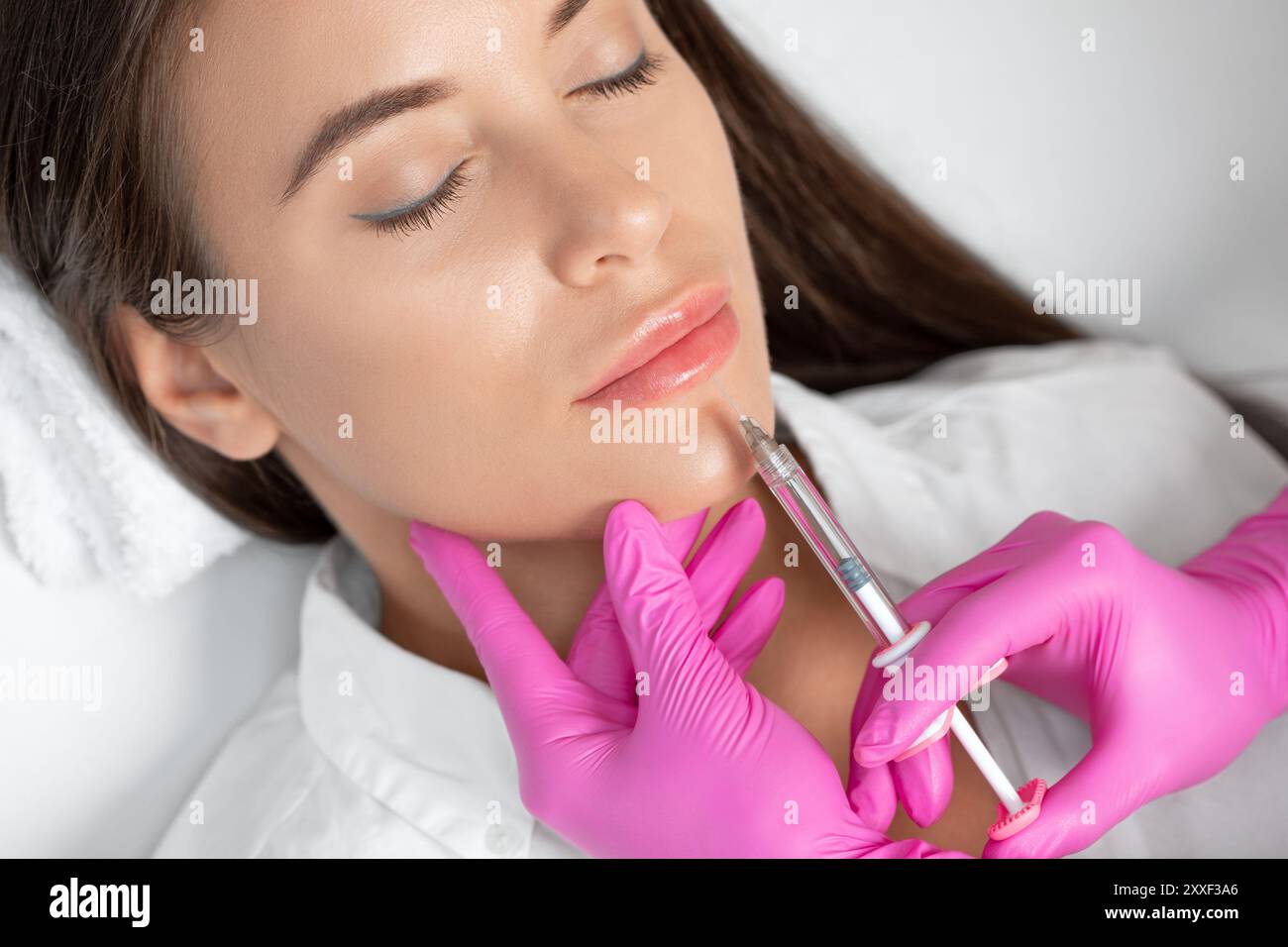Cosmetologist does injections for lips augmentation and anti wrinkle in ...