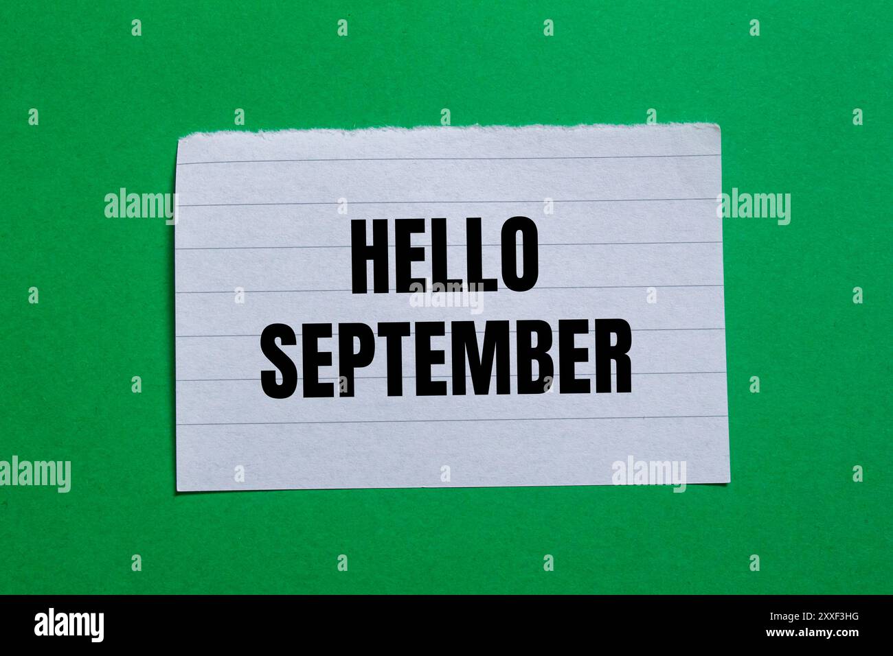 Hello september message written on ripped torn paper piece with green ...
