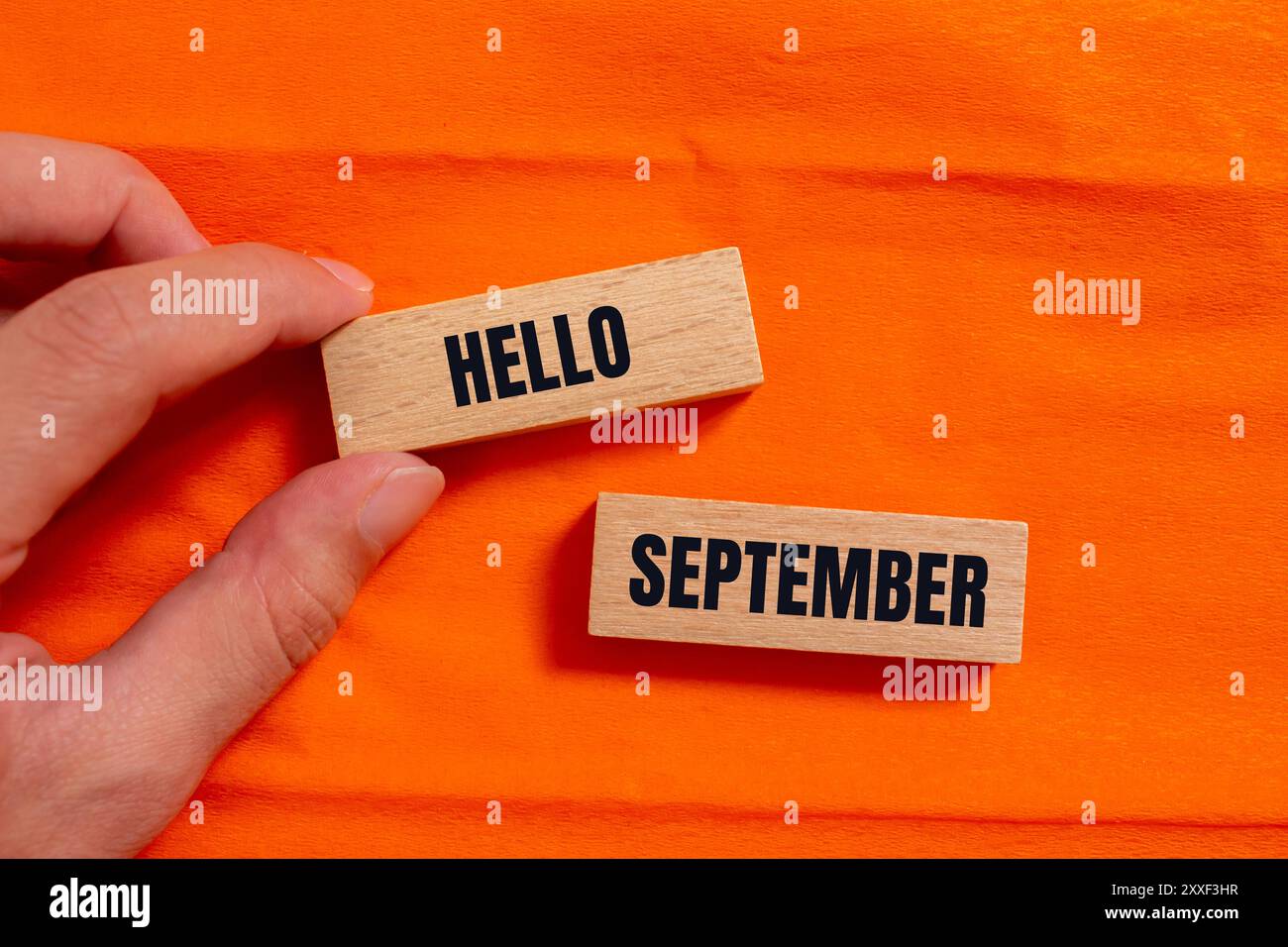 Hello september message written on wooden blocks with orange background ...