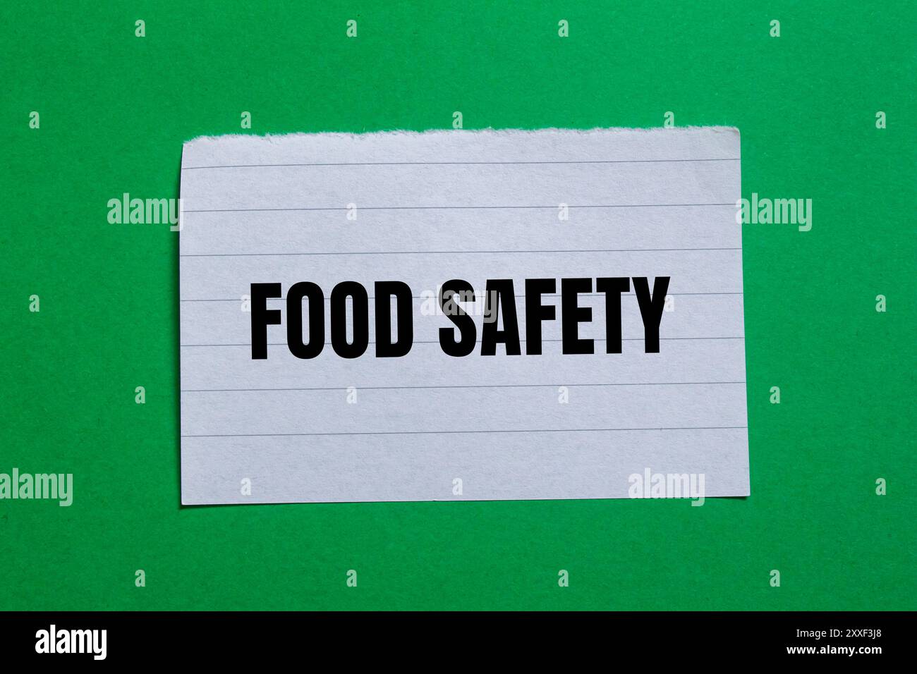 Food safety message written on ripped torn paper piece with green ...