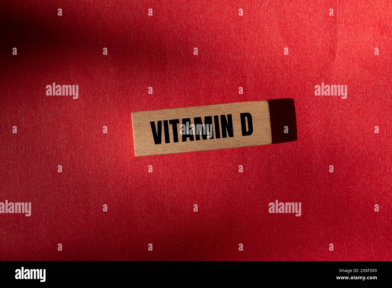 Vitamin d message written on wooden block with red background ...