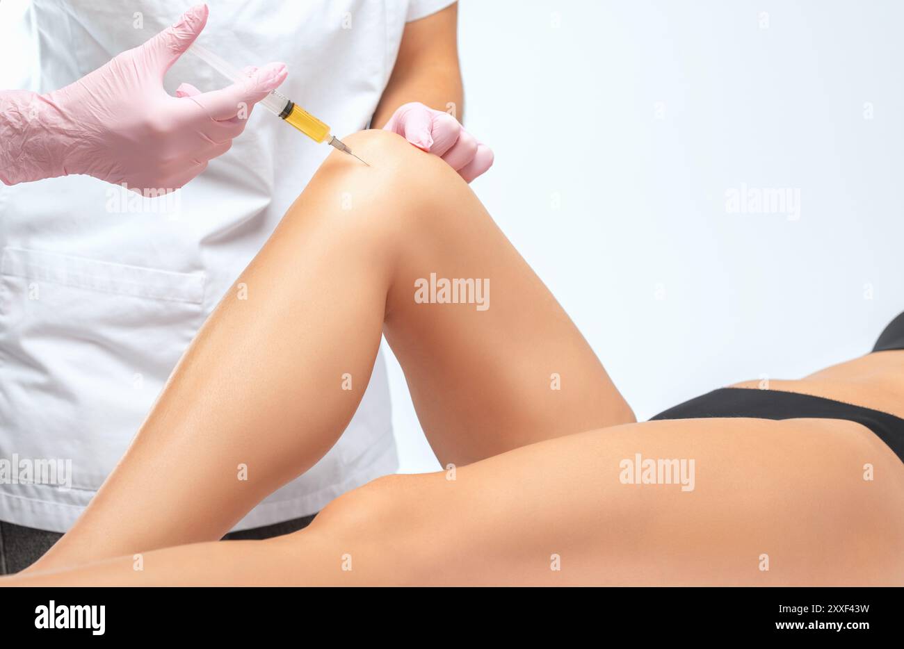 Doctor doing stem cell therapy on a patient's knee after the injury. Treating knee pain with ...