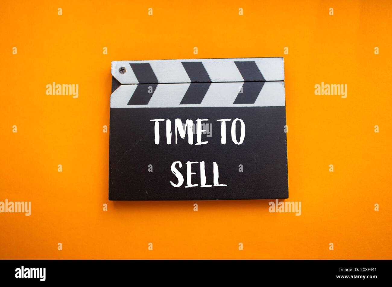 Time to sell message written on movie clapper board with orange ...