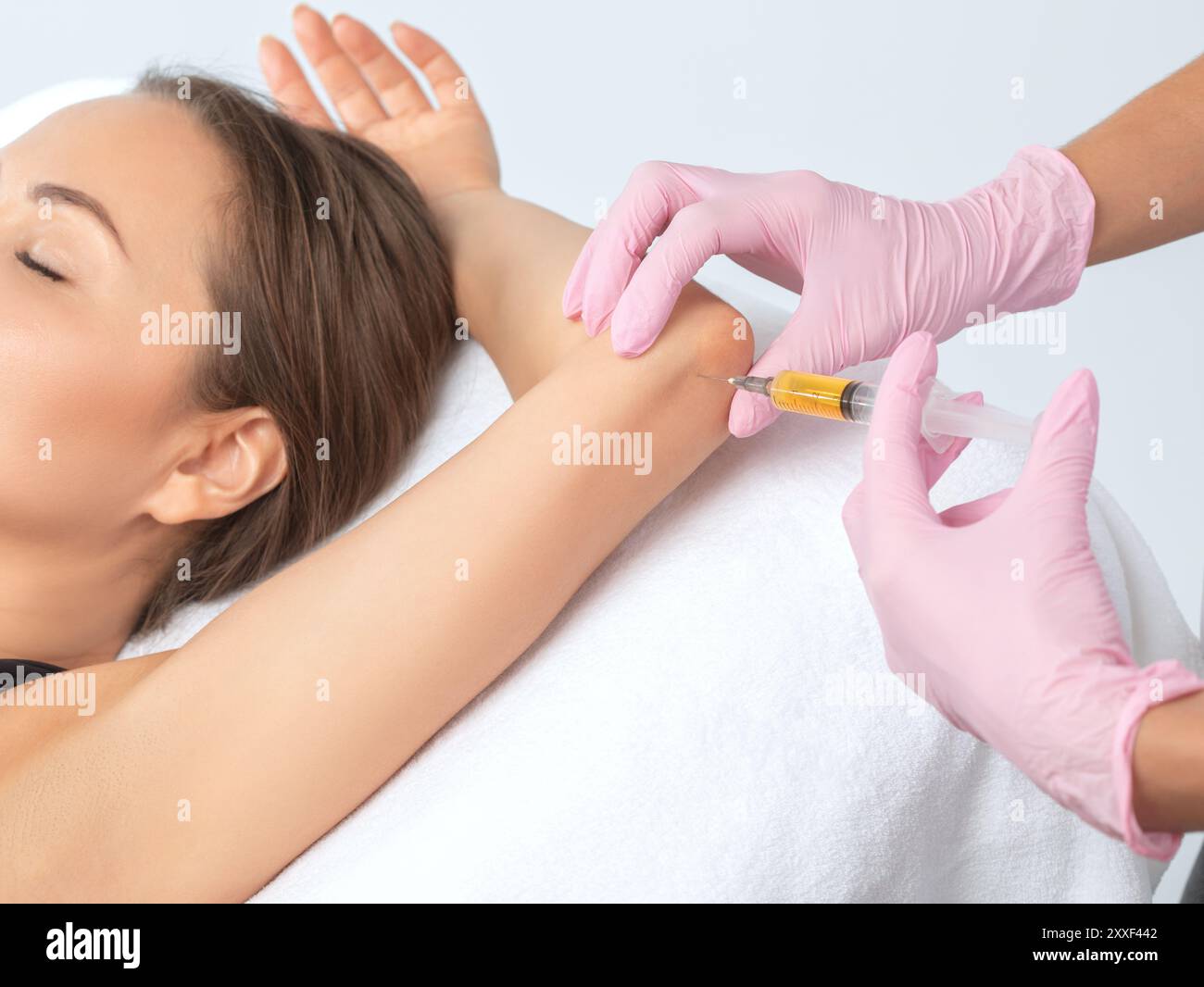 Doctor doing stem cell therapy on a patient's elbow after the injury. Treating knee pain with ...