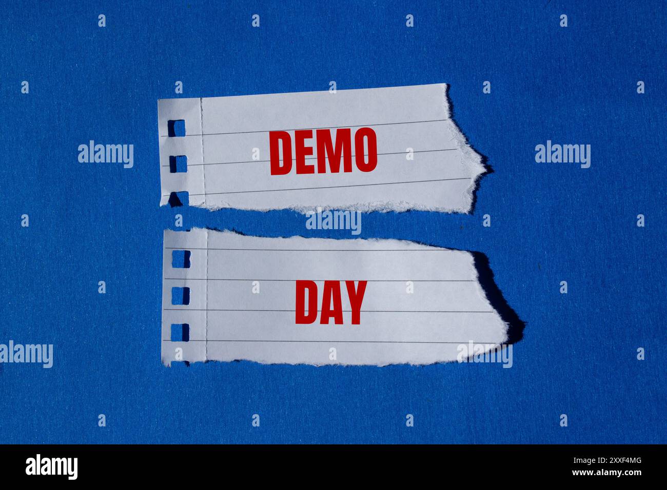 Demo day message written on ripped torn paper pieces with blue ...