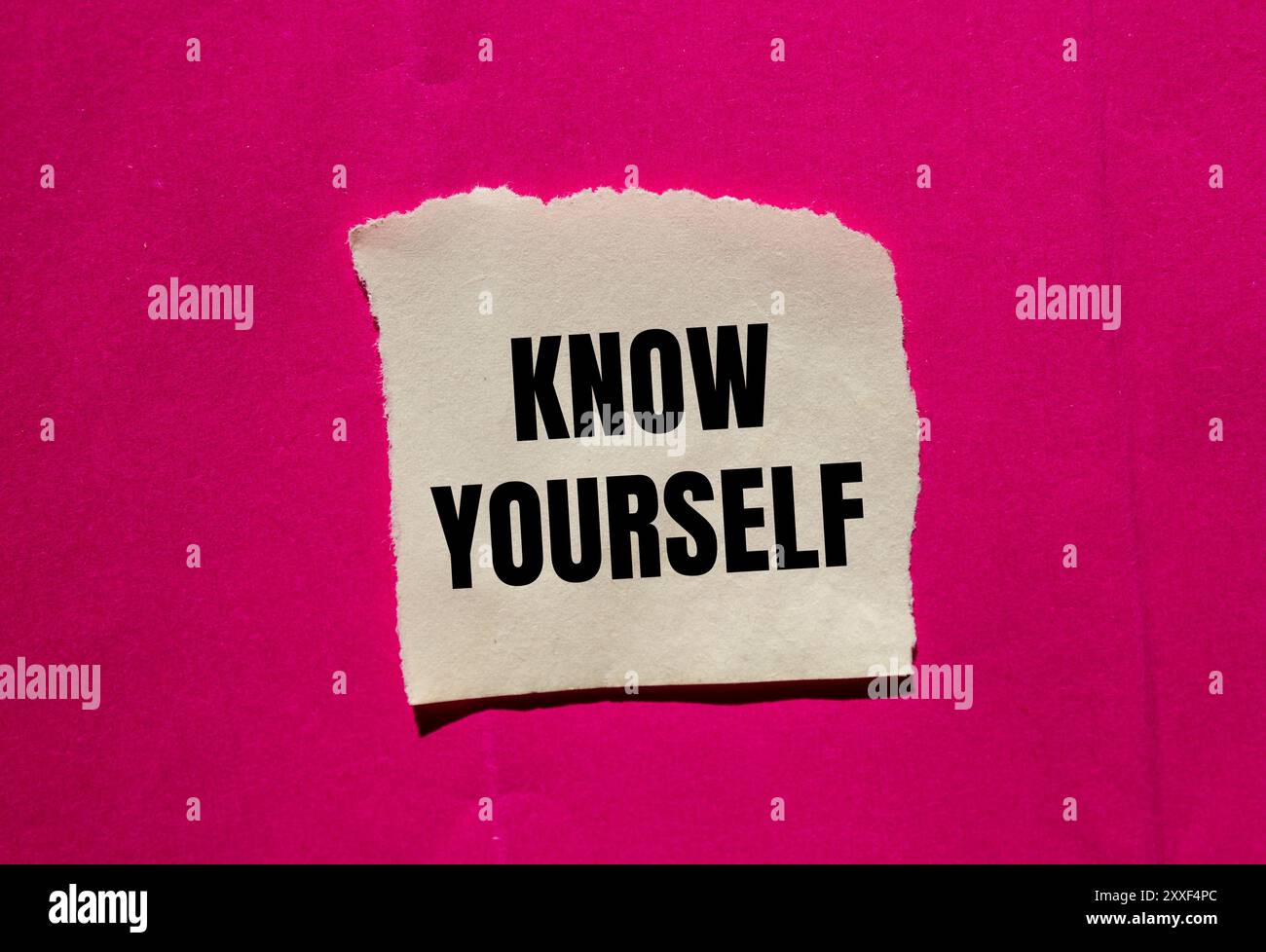 Know yourself message written on ripped torn paper piece on pink background. Conceptual know ...