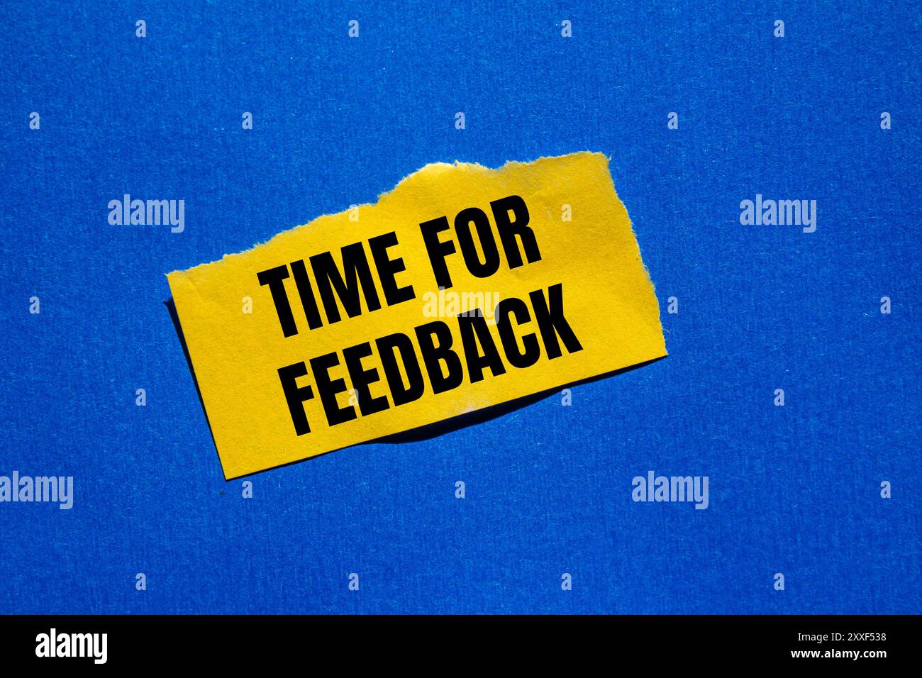 Time for feedback message written on ripped torn yellow paper piece ...
