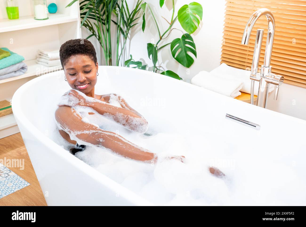 A woman is leisurely enjoying a bath in a bathtub filled with foam ...