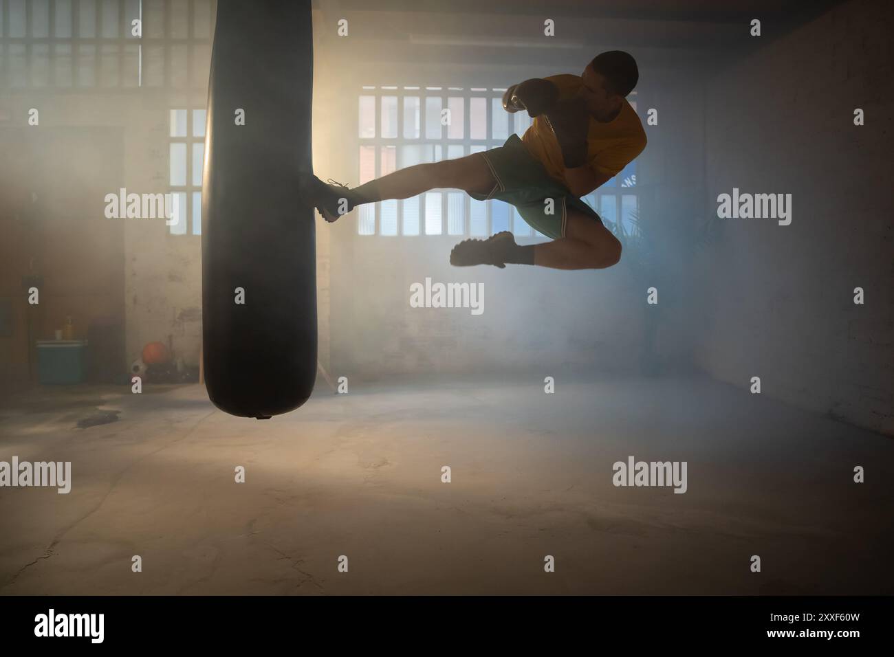 Aerial flying kick Kickboxing or martial arts fighter punching bag in ...