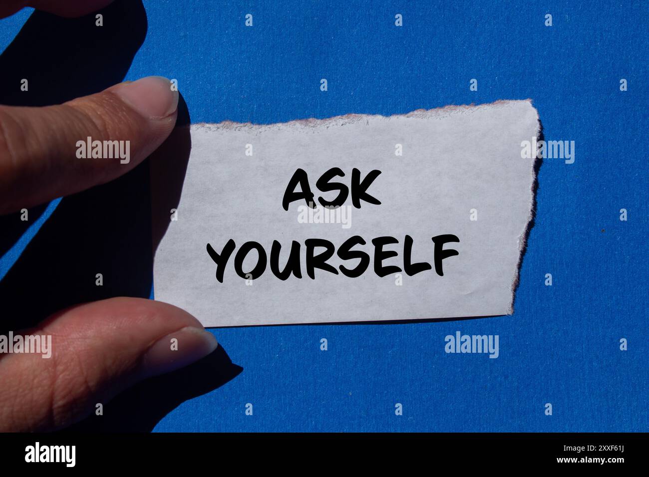 Ask yourself message written on ripped torn paper with blue background. Conceptual ask yourself ...
