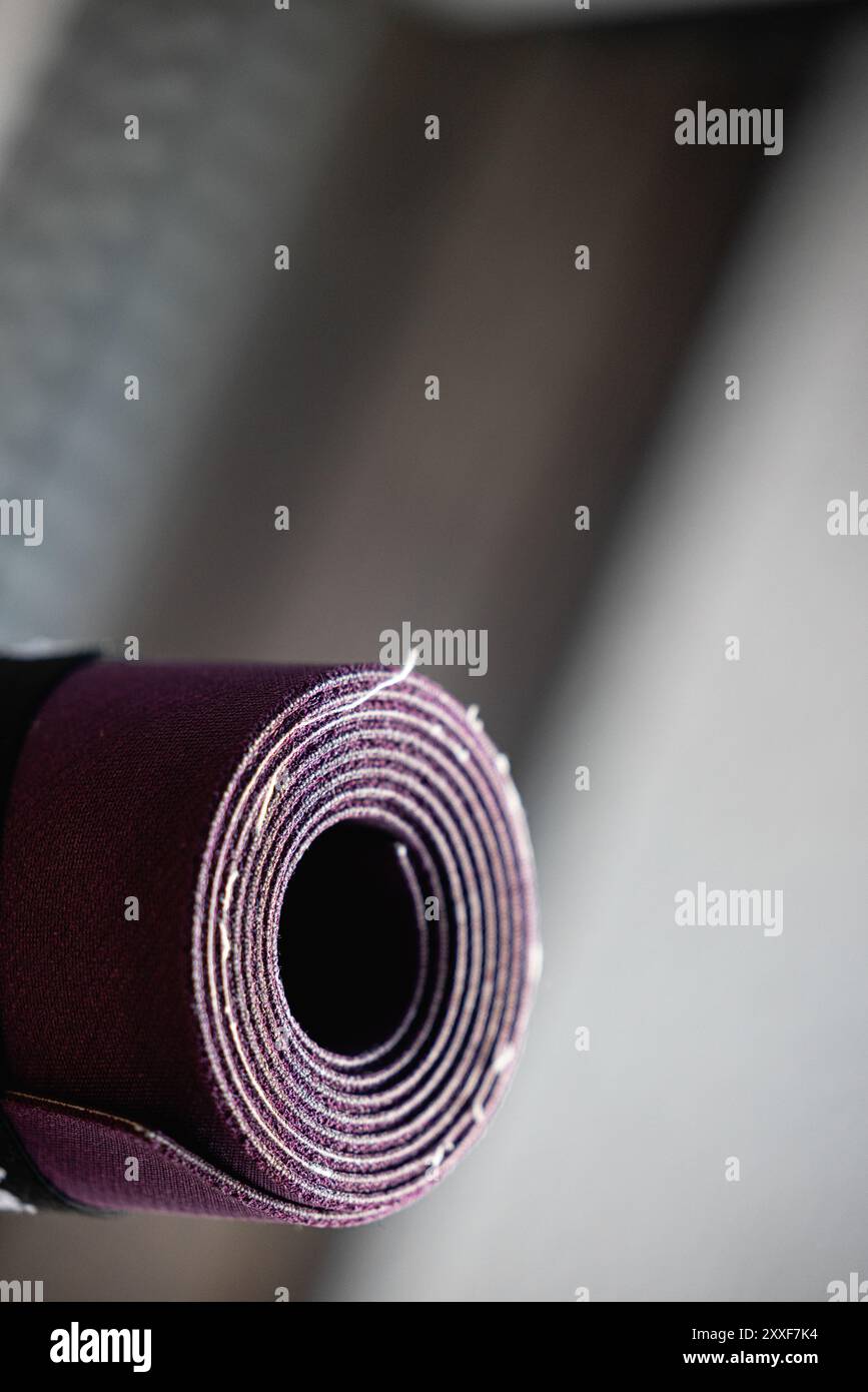 A yoga mat viewed from above, showing a rolled-up mat. Materials for ...
