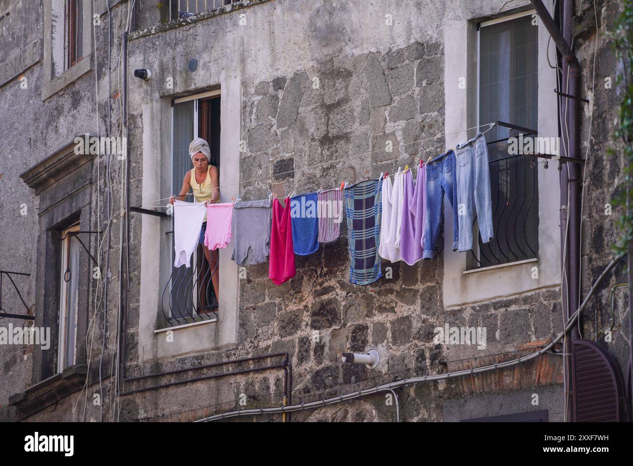 Marta, Italy. 24 August 2024. A woman hanging the laundry washing on ...
