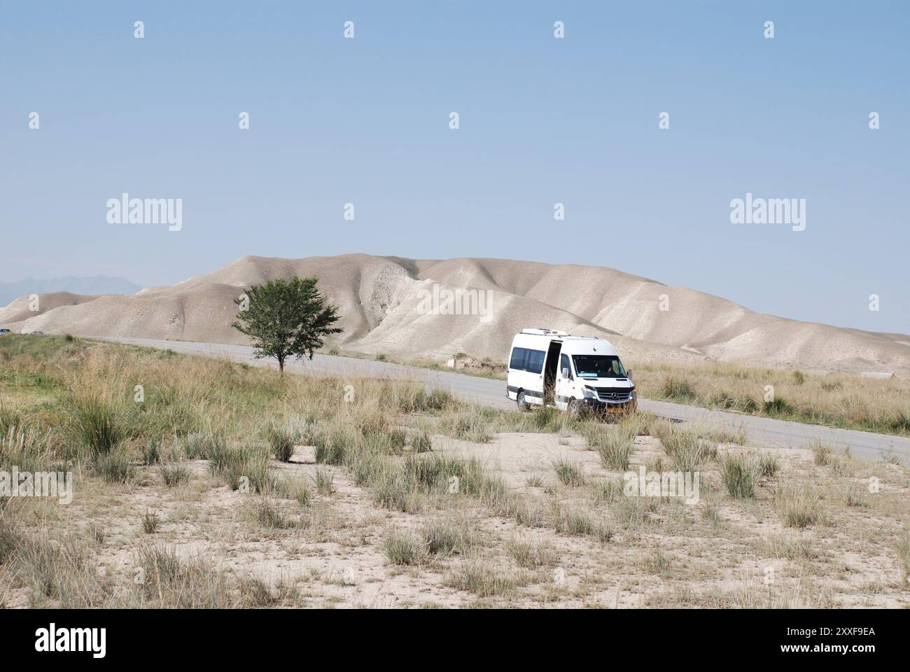 A mini bus parked by the roadside in the mountain landscape of ...