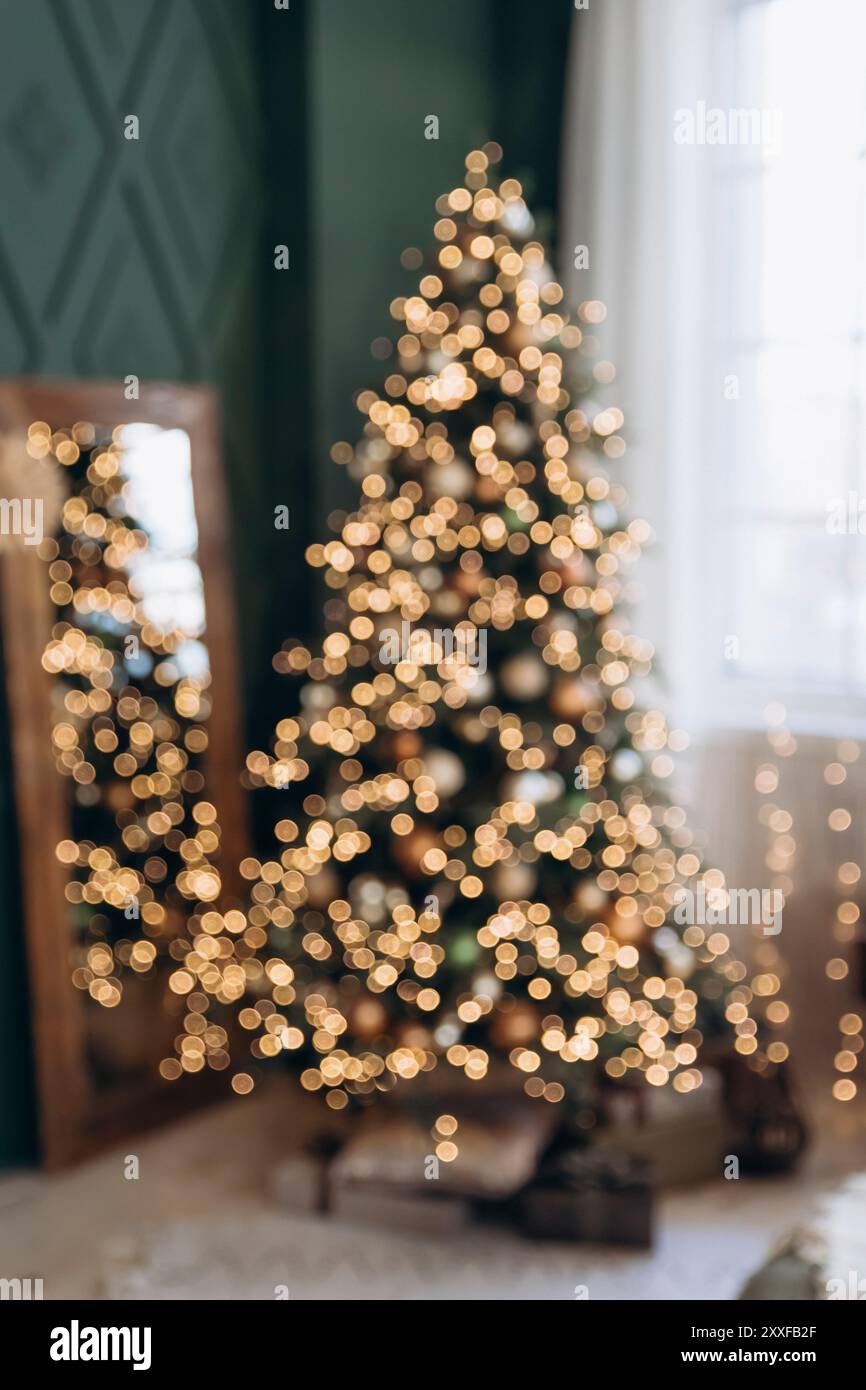 Festive background featuring a blurred Christmas tree adorned with ...