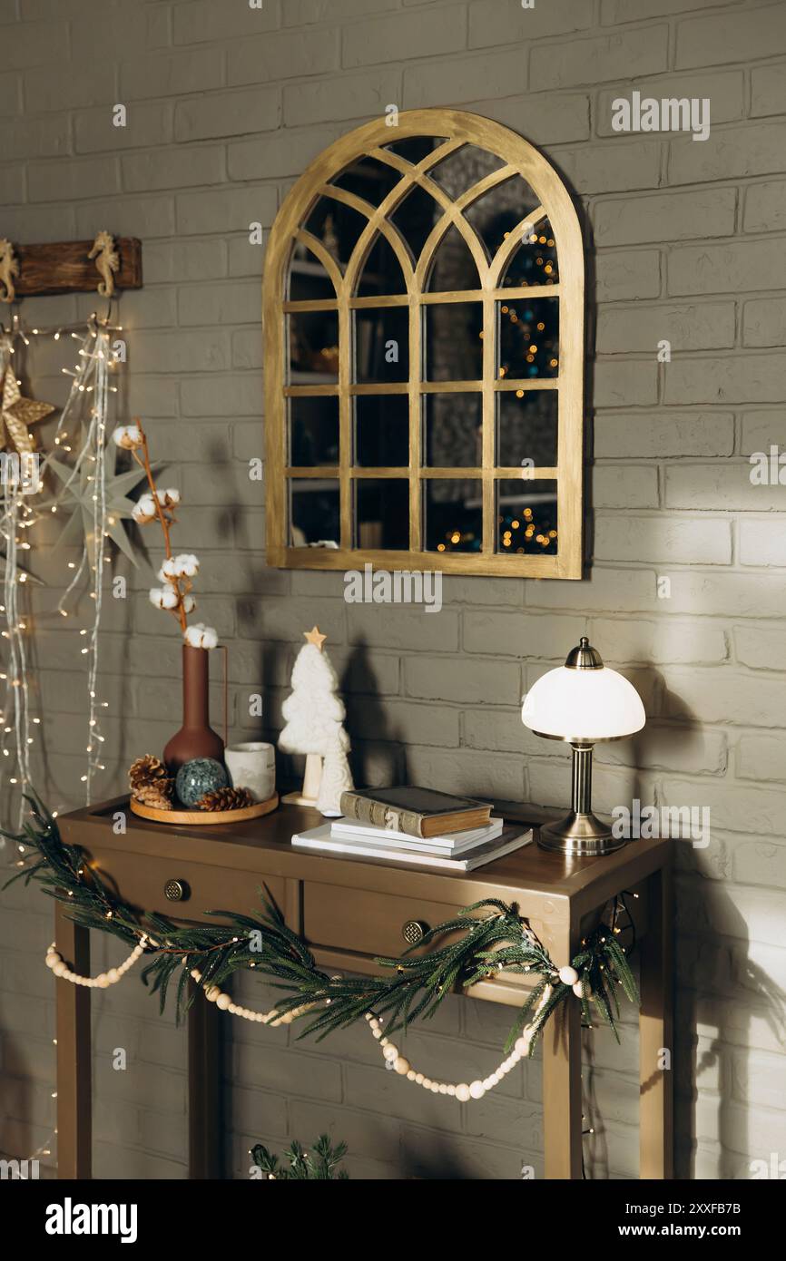 Wooden console table with Christmas decor, mirror with arched frame on ...