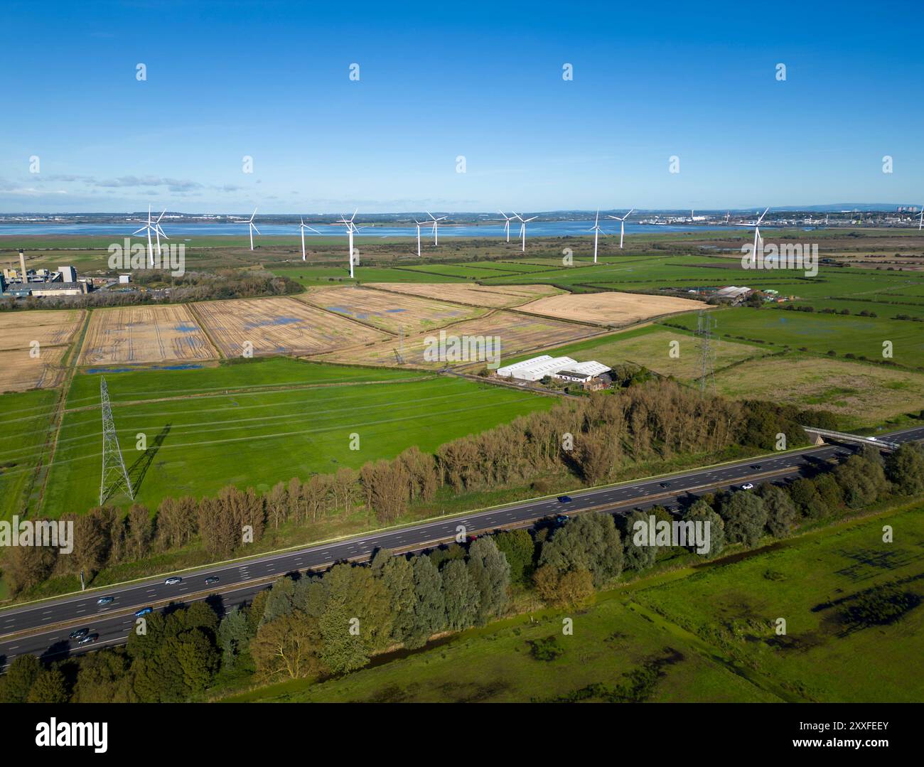 Wind turbines and M56 motorway at Helsby village, Cheshire, England ...
