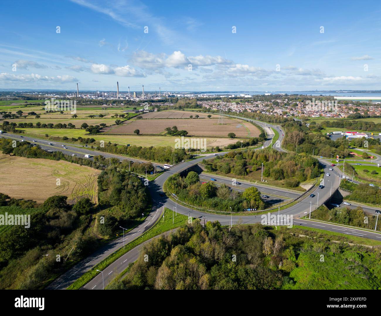 Traffic on the M56 motorway at Junction 14, Helsby with Stanlow oil ...