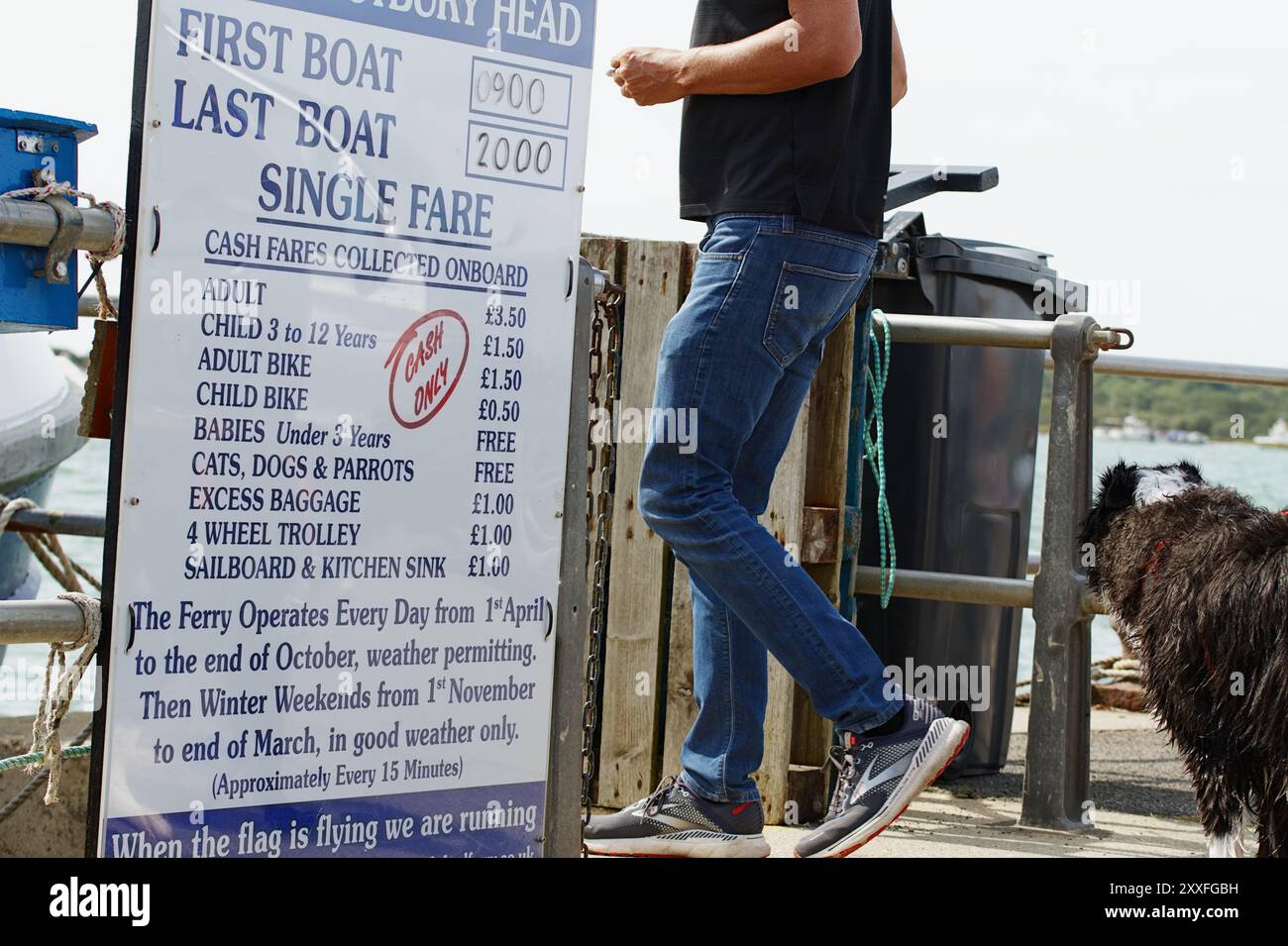 Price List Sign And Man And Dog Walking Onto The Mudeford Spit Ferry ...
