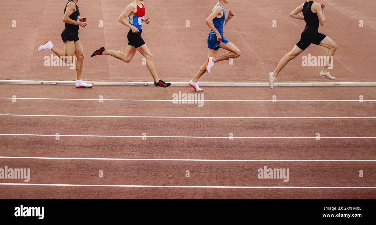 side view four athletes running 800 meters at stadium Stock Photo - Alamy