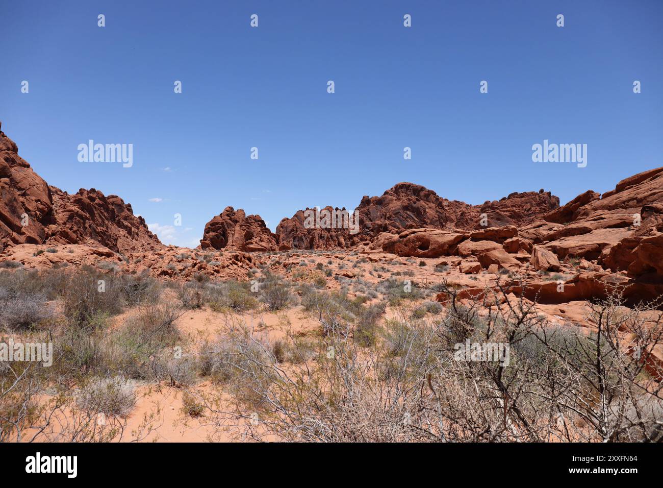 A desert landscape with red Sandstone formations behind a stretch of ...