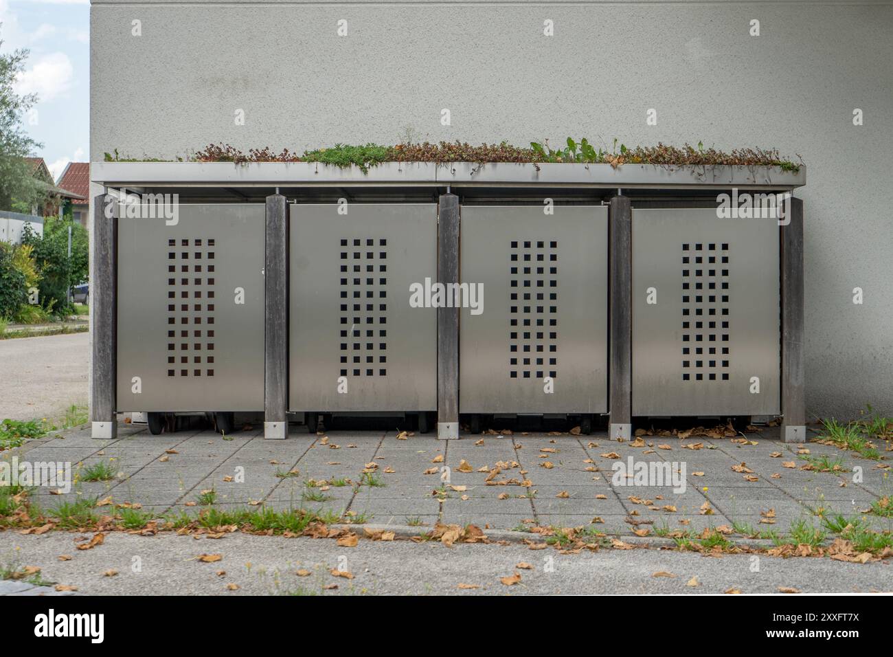 Aesthetic garbage bin with metal doors, wood and plants in front of a ...